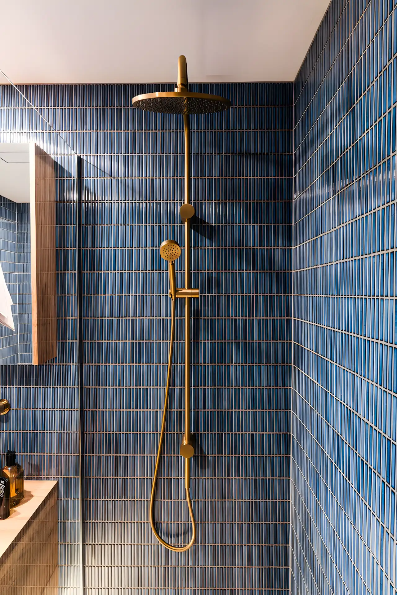 Modern Shower Area with Blue Vertical Tiles and Brass Fixtures